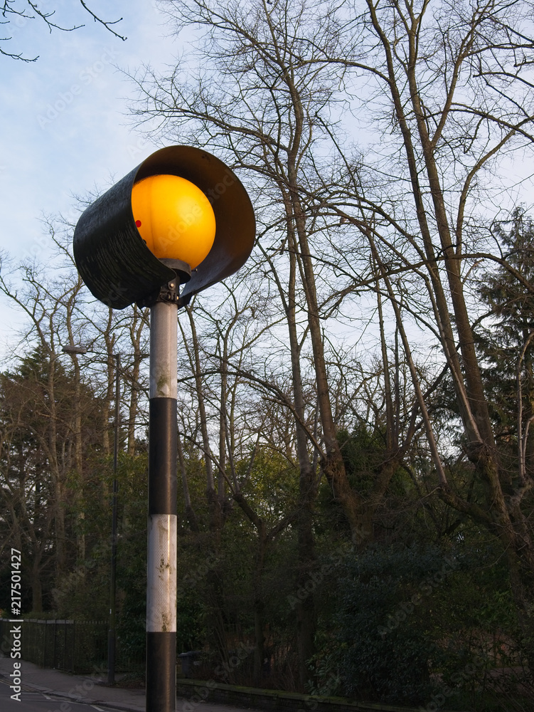 Belisha beacon atop its striped pole. Amber-coloured globe lamp atop a ...