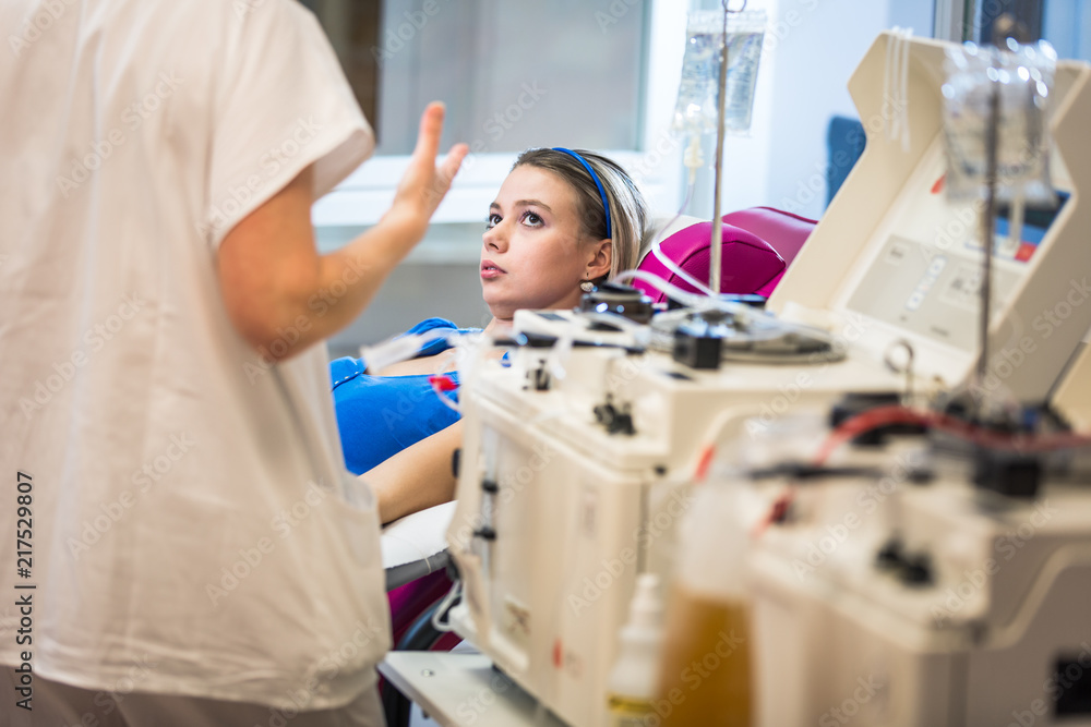 Young woman giving blood in a modern hospital Stock Photo | Adobe Stock