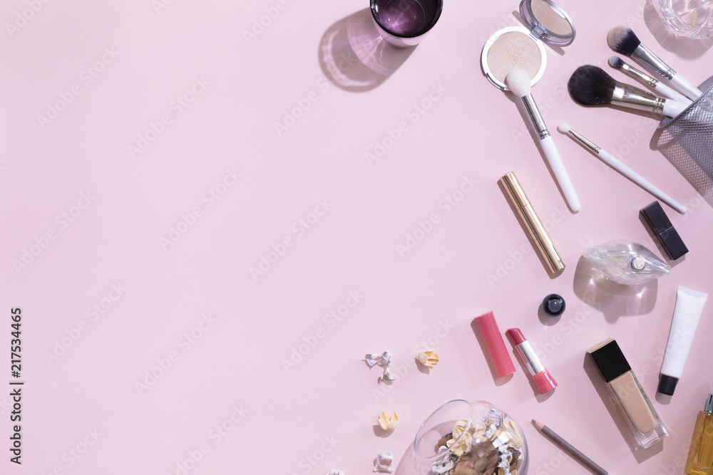 Makeup products on pink color background with hard light and shadows ...