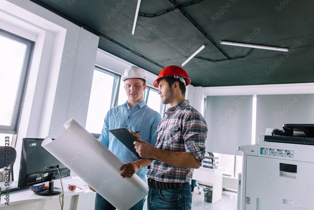 engineers are monitoring the building project in the modern office with ...