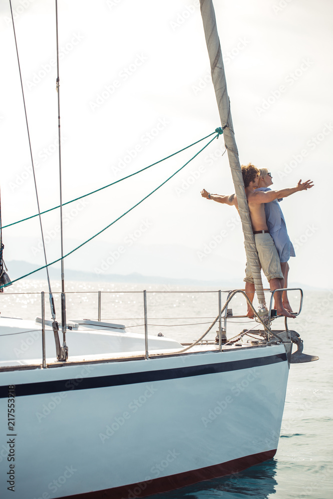 People standing on bow of a sailing boat with hands aside like dramatic ...