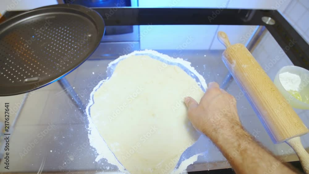 POV placing the pizza dough on to baking dish 4K. Person point of view ...