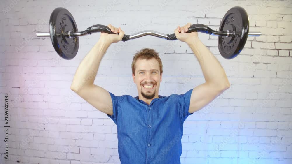Happy person lift up a bar with heavyweights in slow motion 4K. Medium ...