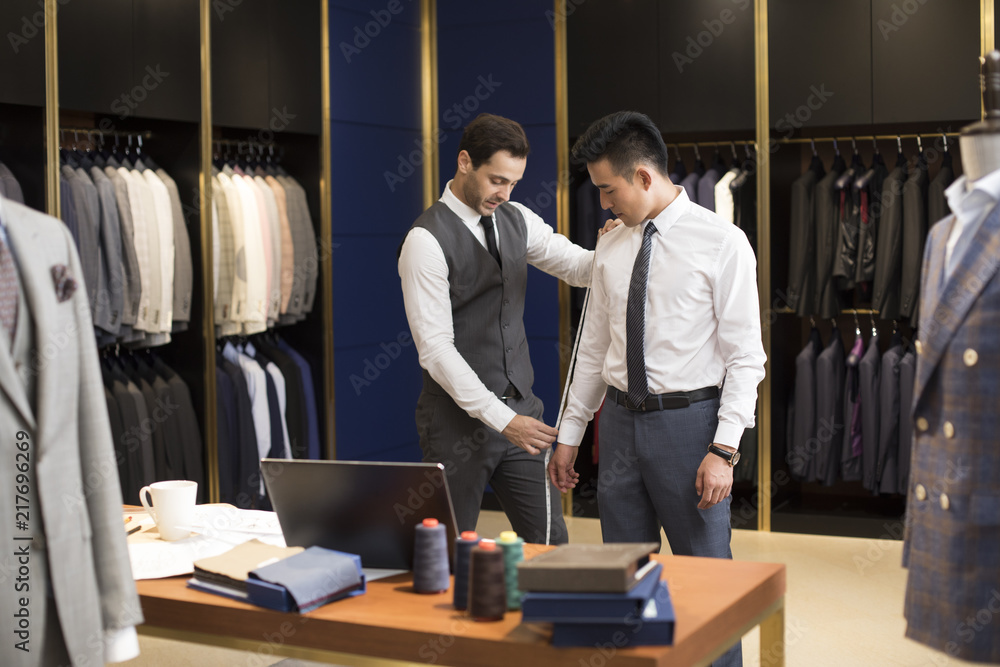 Fashion designer taking measurement of customer Stock Photo | Adobe Stock