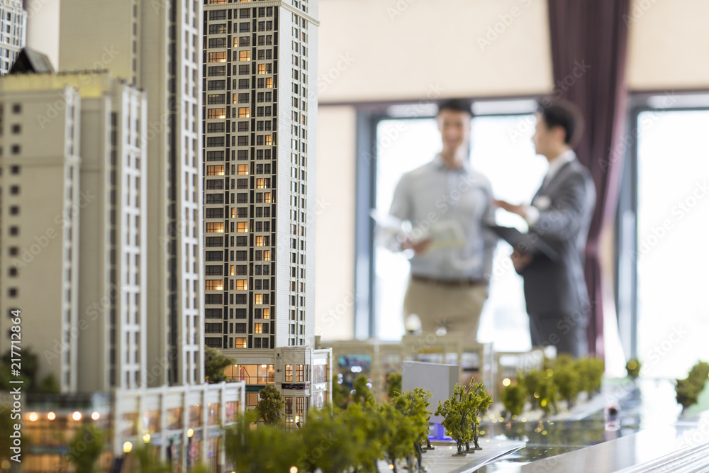 Realtor showing architectural model to young man Stock Photo | Adobe Stock