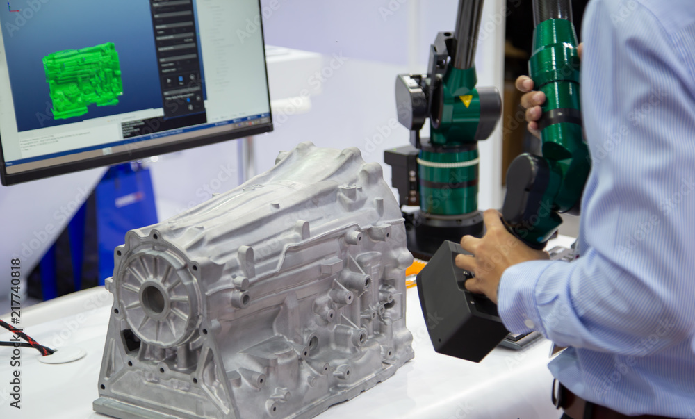 Industrial professional using CMM laser scanner to inspect engine part ...