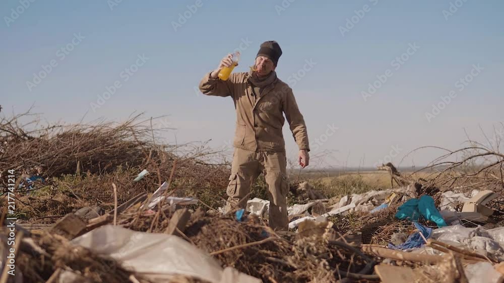 dirty male homeless lifestyle hungry man in a dump looking for clothing ...