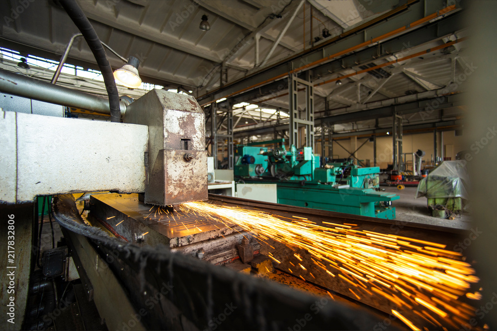 Metal parts on a flat grinder are treated with an abrasive wheel ...