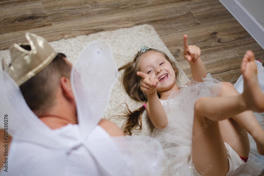 Little daughter and father have fun, dressing in princess costume ...