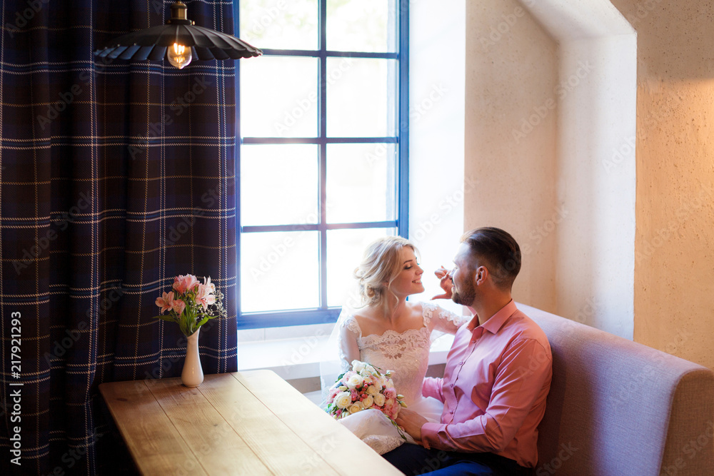 Happy wedding couple hugging and kissing in interior studio. Beautiful ...