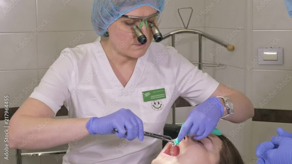 Woman at dentist clinic gets dental treatment to fill a cavity in a ...