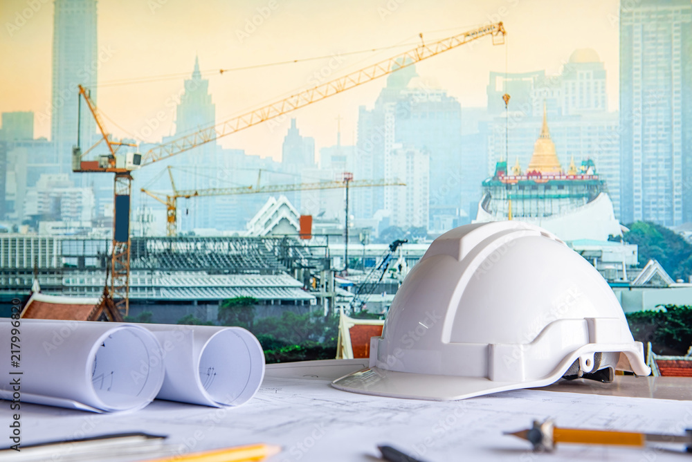 Architectural drawing plan with blueprint rolls, safety helmet and ...