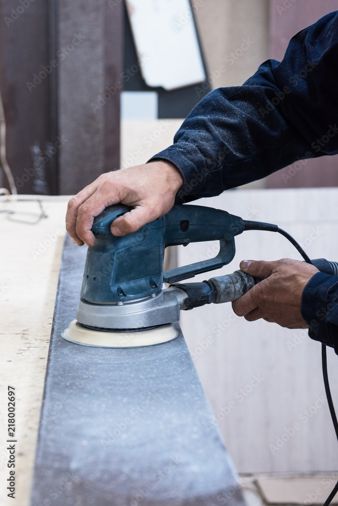Furniture production or craft concept: worker polishing the stone ...
