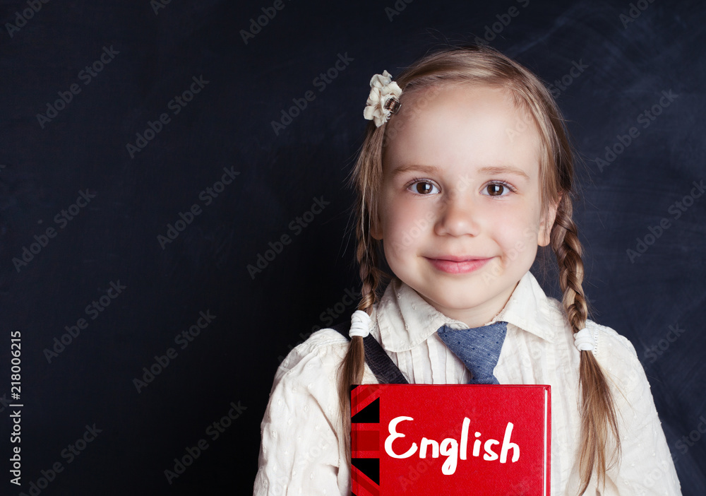 Foto de Little girl student with english book near blackboard in the ...
