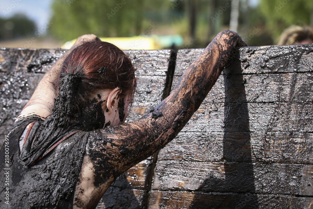 Mud race runners during extreme obstacle races Stock Photo | Adobe Stock
