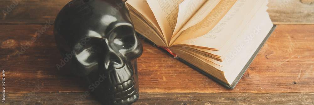 still life art photography on human skull skeleton with book omn desk ...