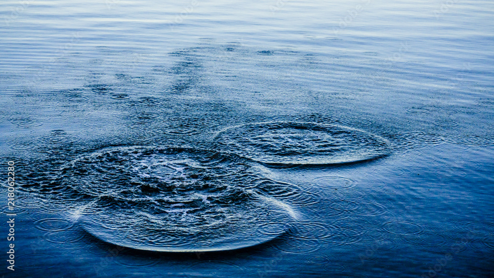 Round droplets of water over the circles on the water. Water drop ...
