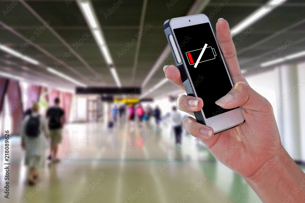 Man using LOW BAT smartphone at airport and blurry background with ...