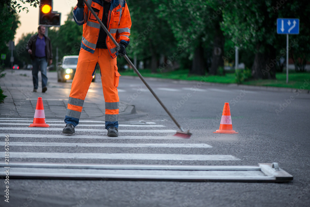 Traffic line painting. Workers are painting white street lines on ...