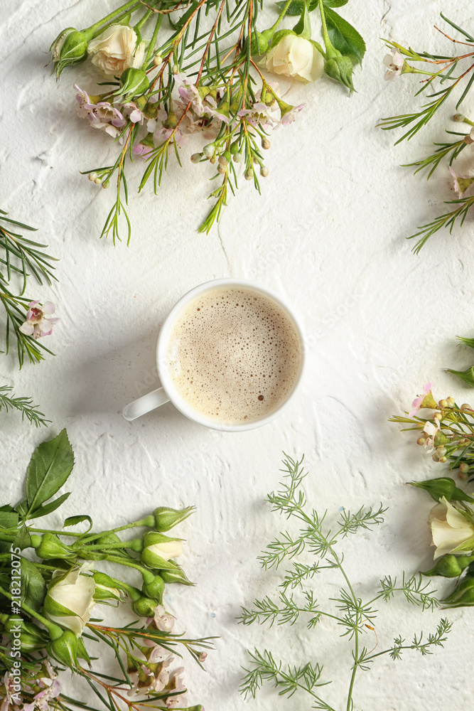 Beautiful flowers with cup of coffee on light textured background, top ...