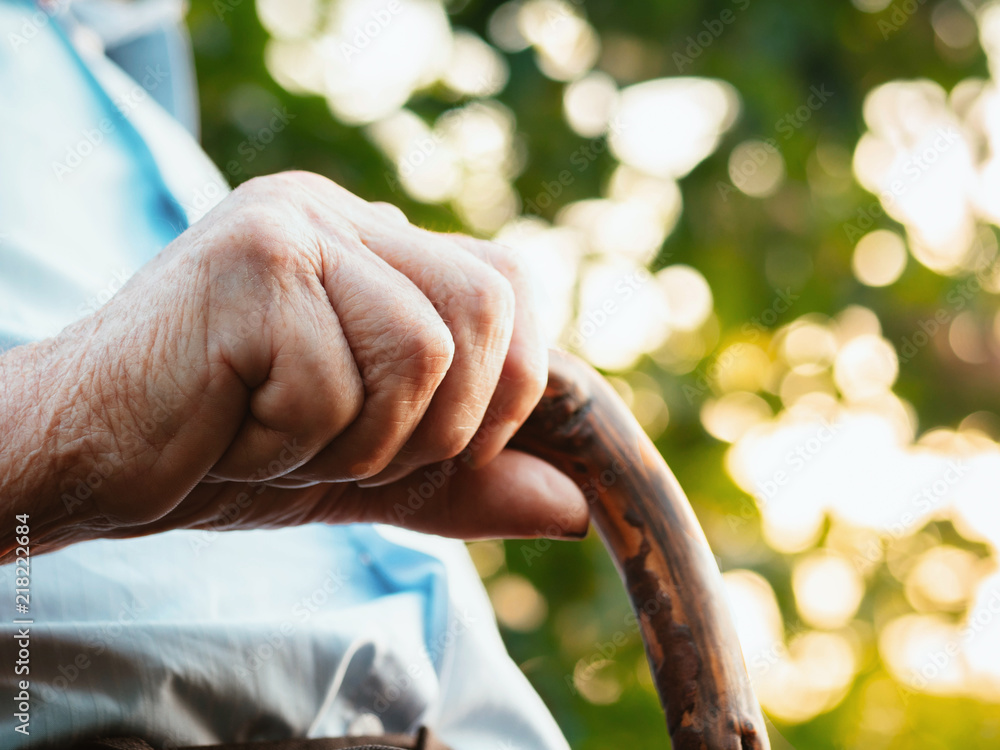 wrinkled old man' hands crossed on the stick. Close-up of a pensive ...