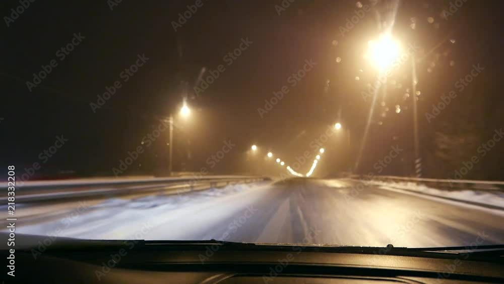Night driving in the car on the wet snow slippery bad road. Bad weather ...