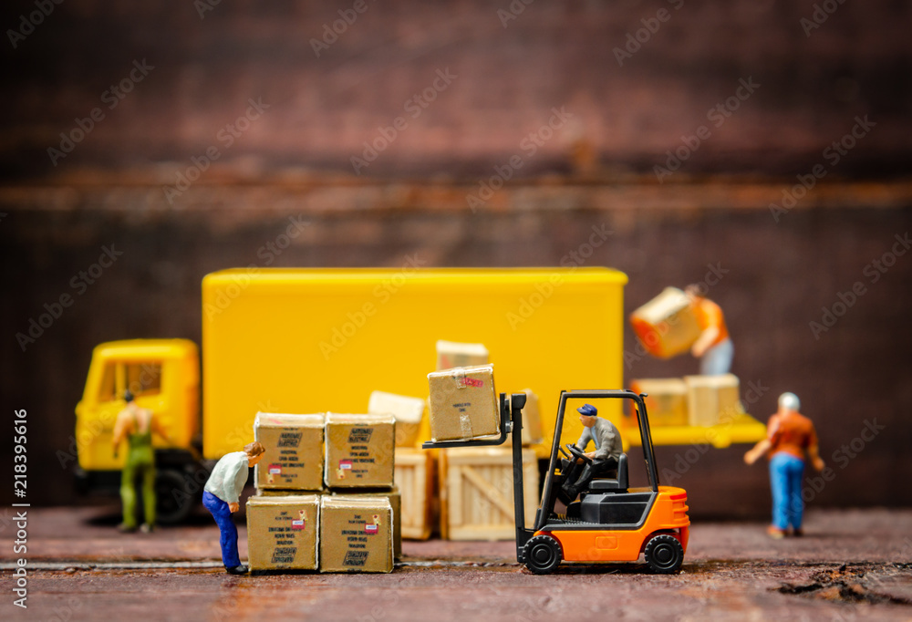 miniature warehouse workers forklift carrying goods box to semi truck ...
