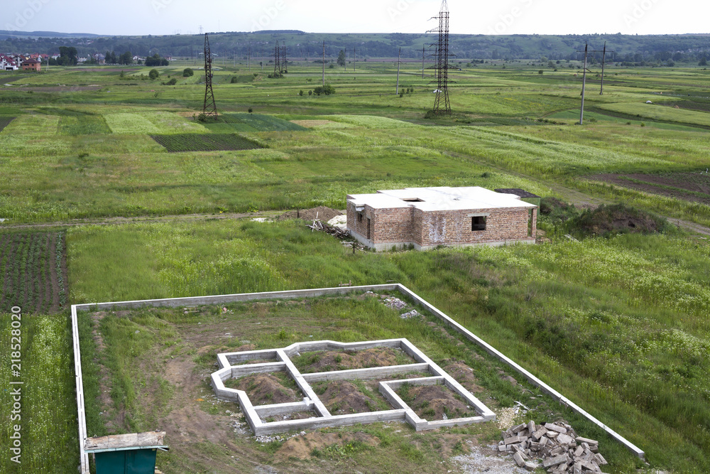 Building site in green field. Trenches dug in ground and filled with ...