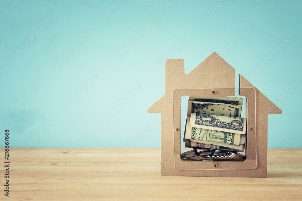 Mortgage concept. Model of a wooden house with financial savings. house ...