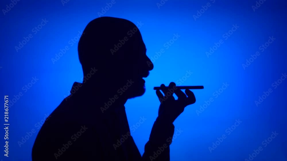 Silhouette of senior man using mobile on blue background. Male's face ...
