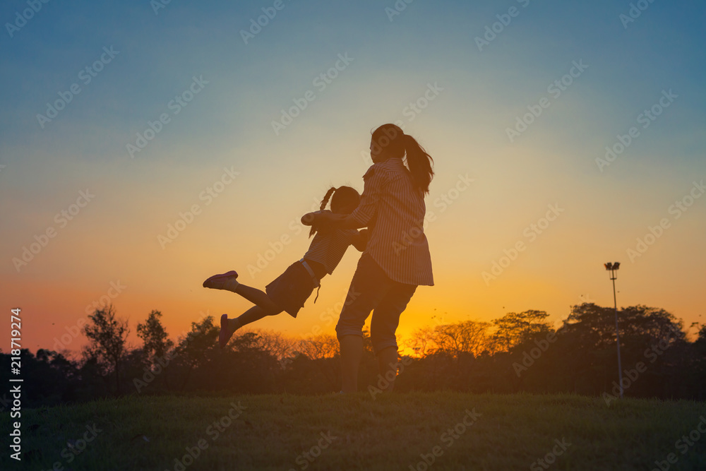 Silhouette of a happy little girl child running into the arms of his ...