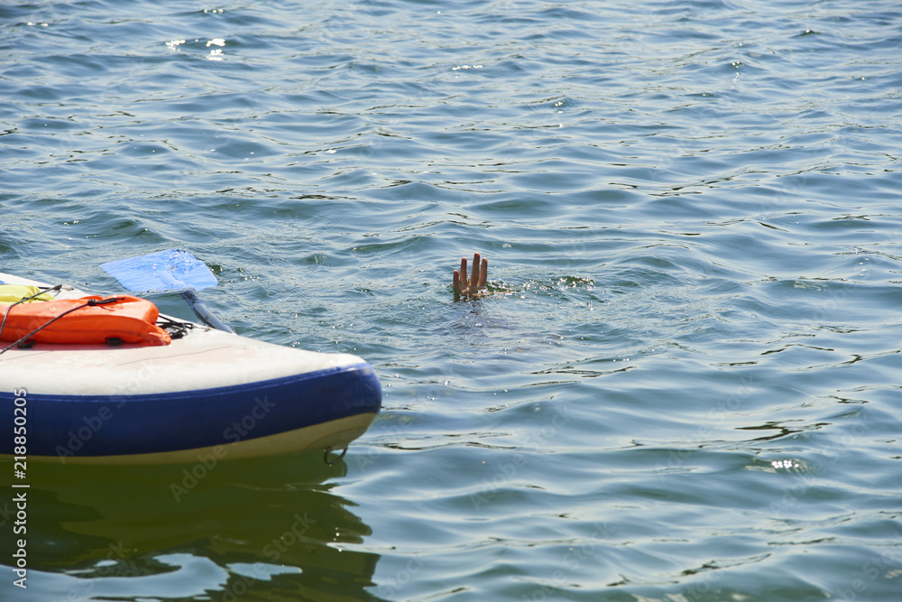 Hand of a drowning child boy leaning out of the water beside the ...