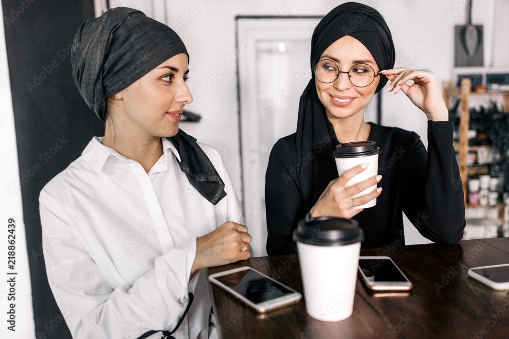 Muslim hijab girl drinking coffee sitting at a table in a cafe Stock ...