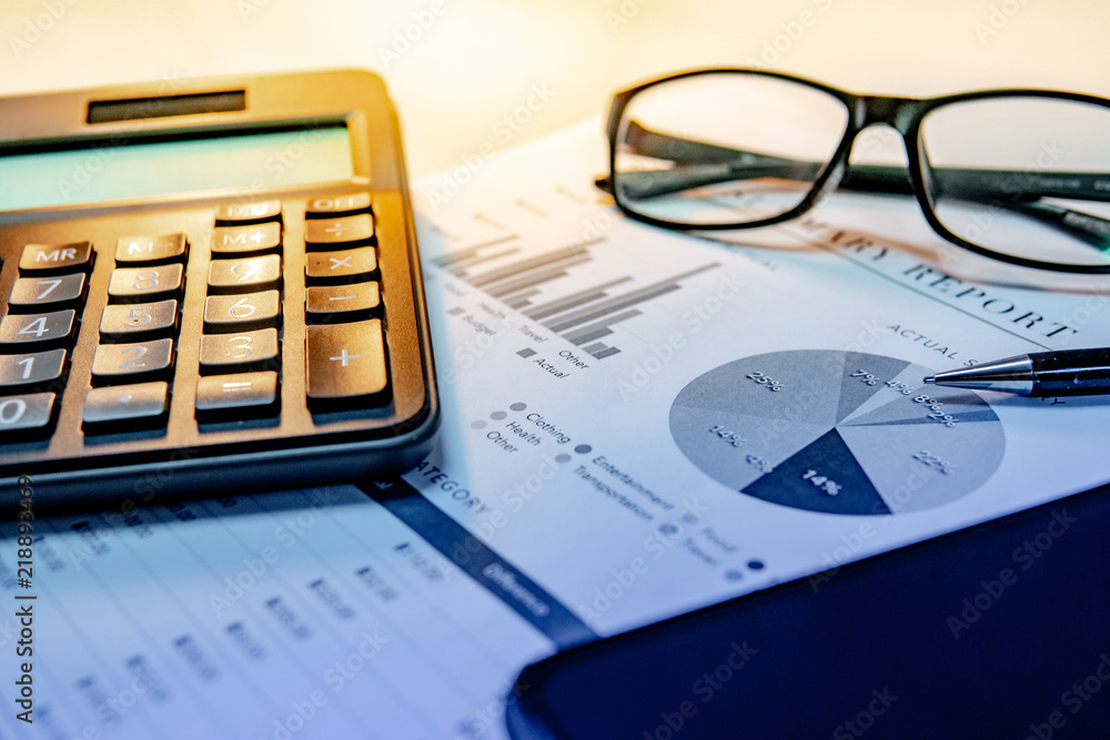 Calculator, eyeglasses, pen, smartphone and summary report paperwork ...