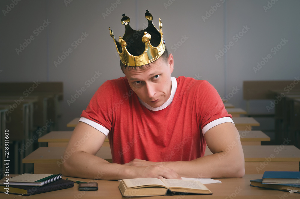 Arrogant student boy with golden crown above his head with an insolent ...