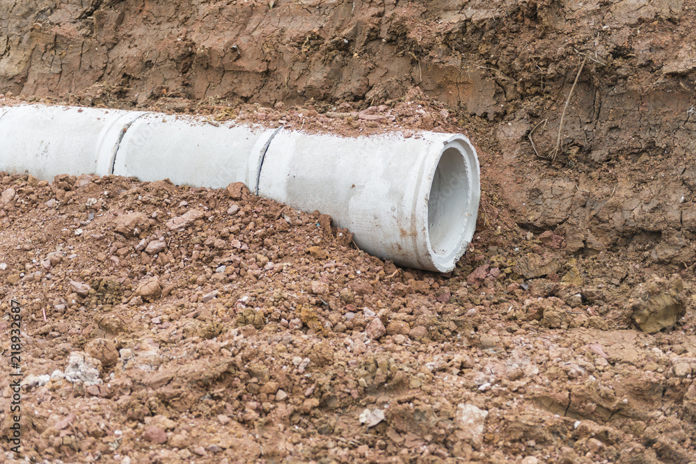 Row of Concrete Drainage Pipe dig on a Construction Site under the road ...