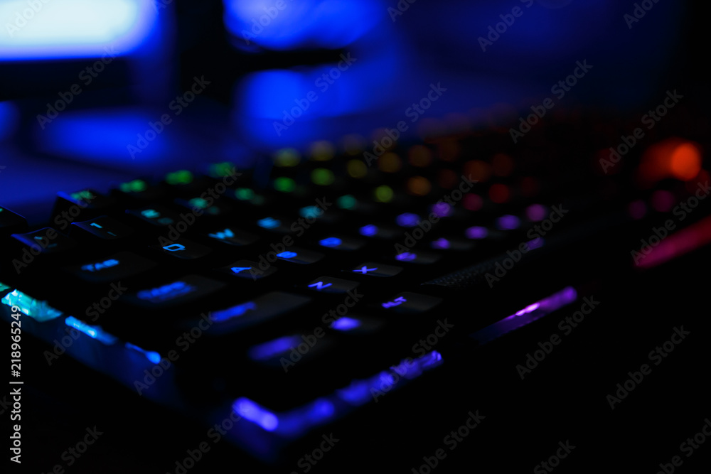 Closeup photo of workplace with led rainbow backlight gaming keyboard ...