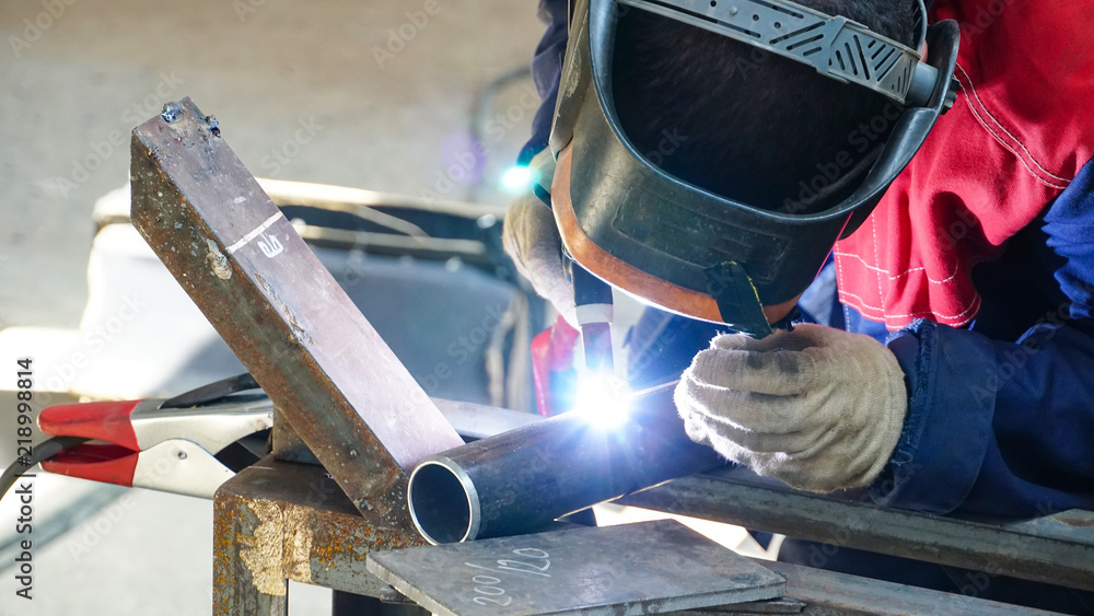 The professional welder works with argon-arc welding. Welds a pipe with ...