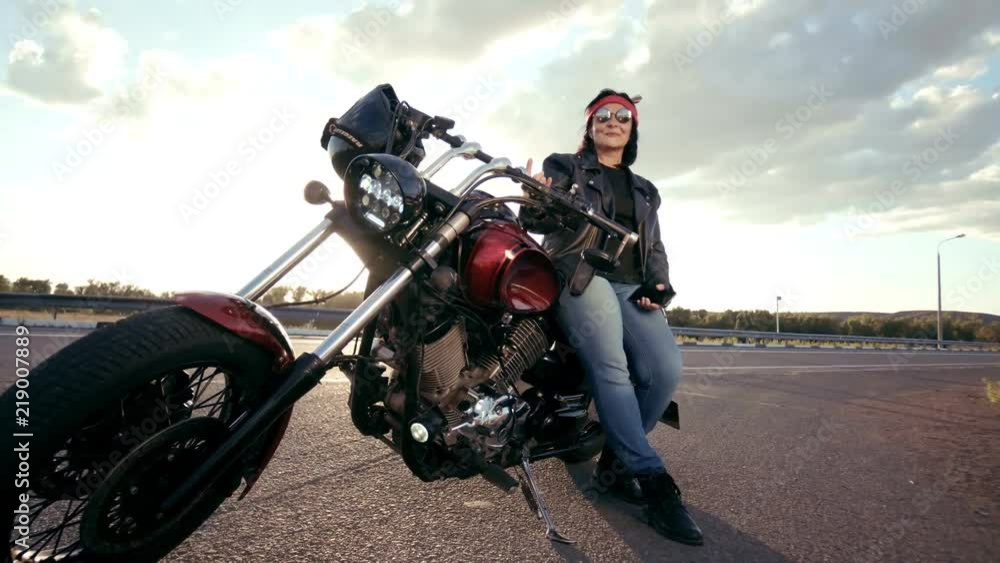 Biker old woman in leather jacket and gloves sitting on his cool ...