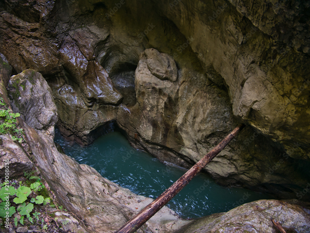 Ein Baumstamm liegt quer in einer Schlucht Photos | Adobe Stock