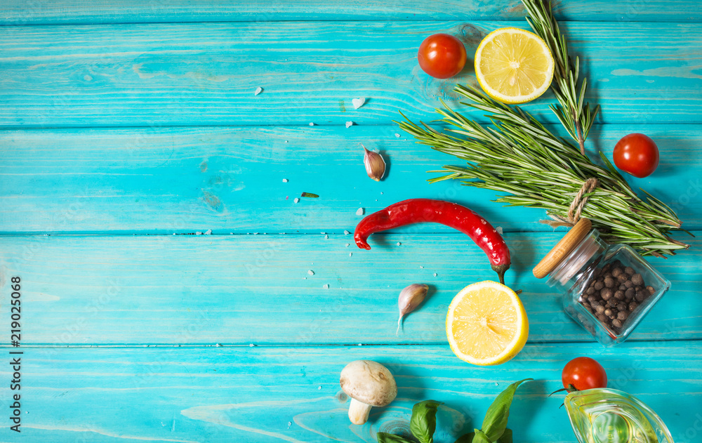 Food cooking background on blue wood table. Rosemary, basil, tomatoes ...
