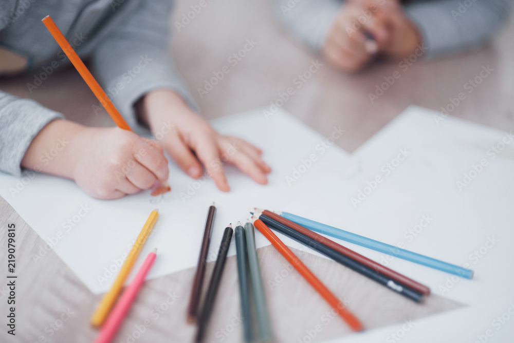 Children lie on the floor in pajamas and draw with pencils. Cute child ...