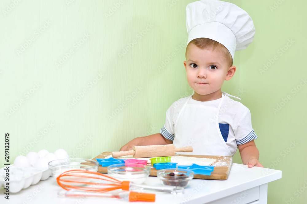 Cute two year old boy dressed as chef tries to roll out dough and makes ...