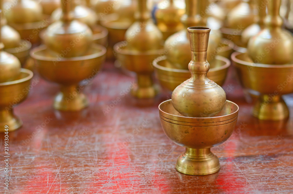 A golden brass pour ceremonial water jar used in traditional Buddhists ...