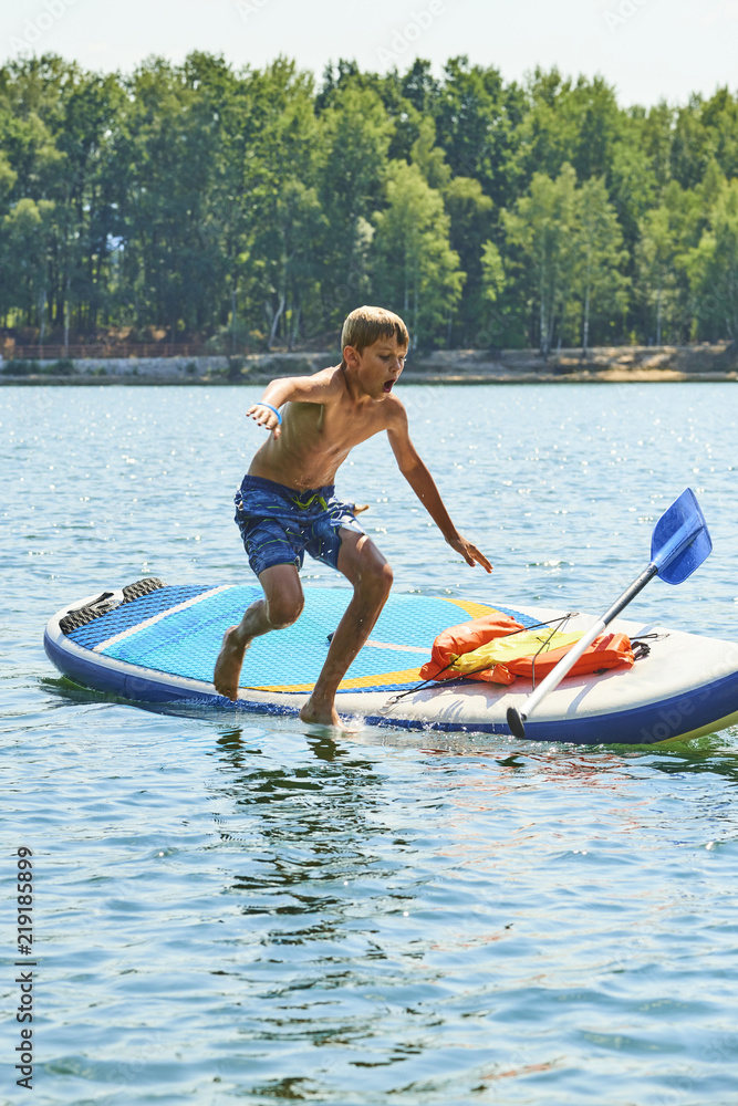 Child boy falling from a paddleboard into the water Stock Photo | Adobe ...