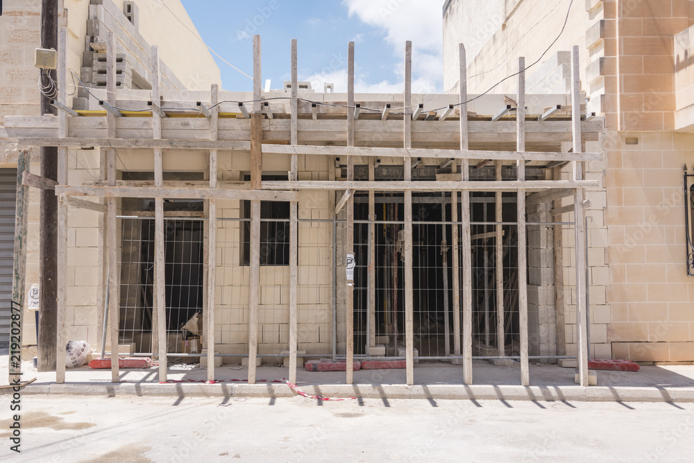 Traditional wooden poles used as support scaffolding at a house home ...