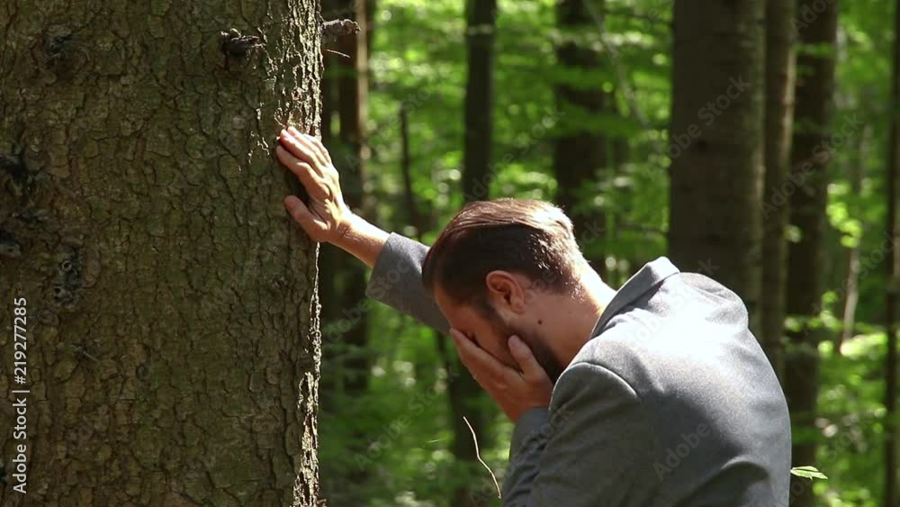 Desperate man praying in nature. Sad and lost man in the forest ...