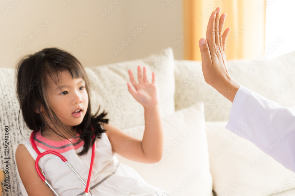 Happy little cute girl on consultation at the pediatrician. Girl is ...