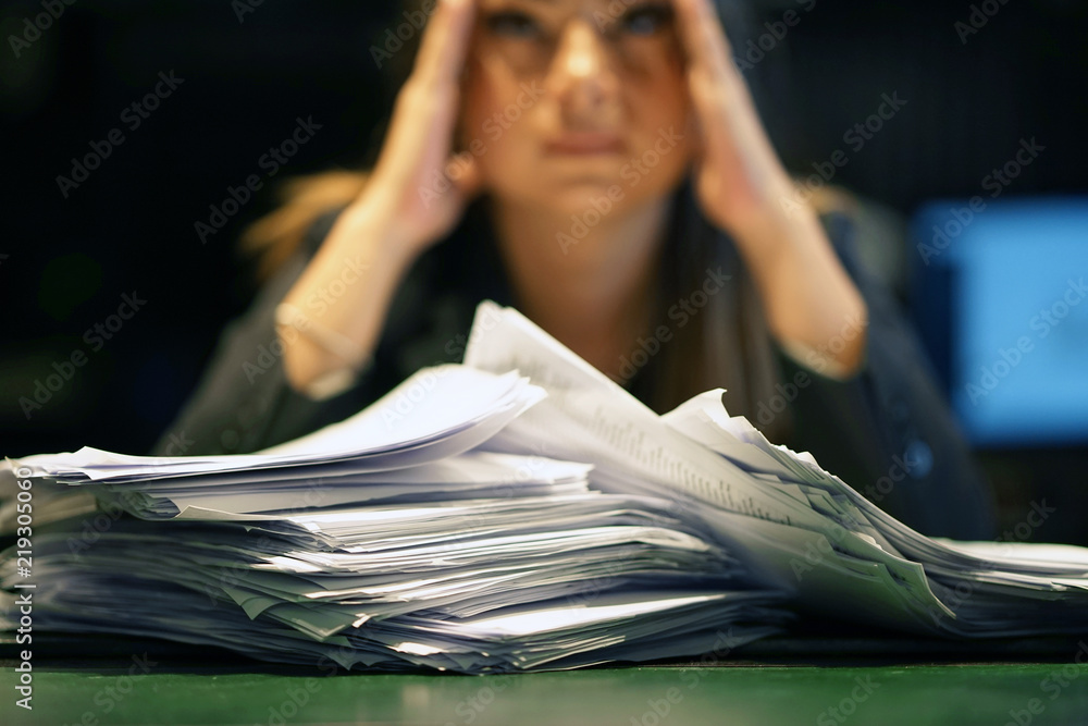 Close-up of office worker is distressed with a lot of paperwork in ...