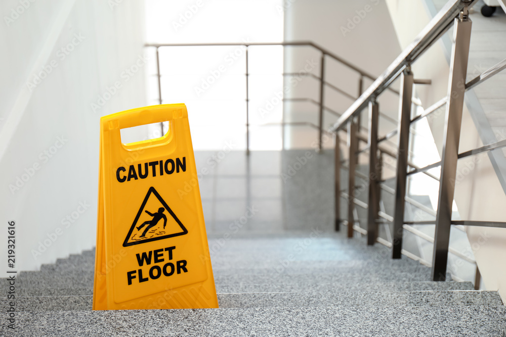 Safety sign with phrase Caution wet floor on stairs. Cleaning service ...